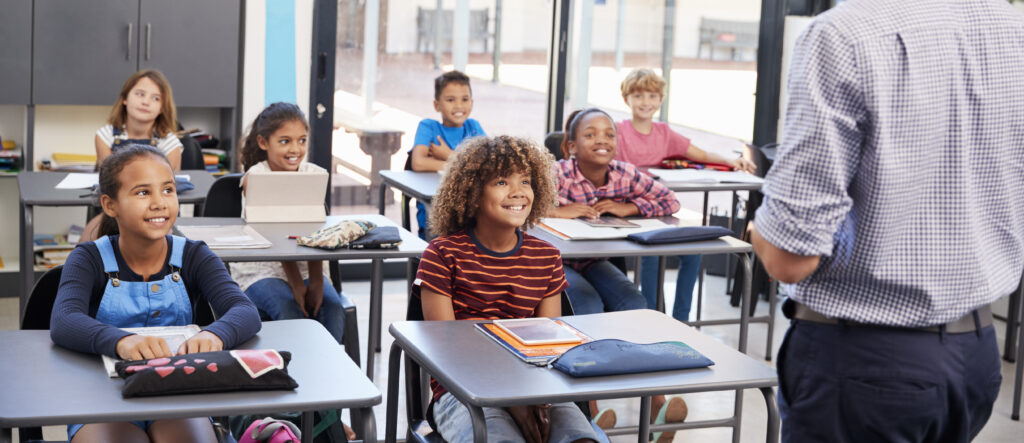 Teacher in front of school class, back view, panoramic - MindFuel